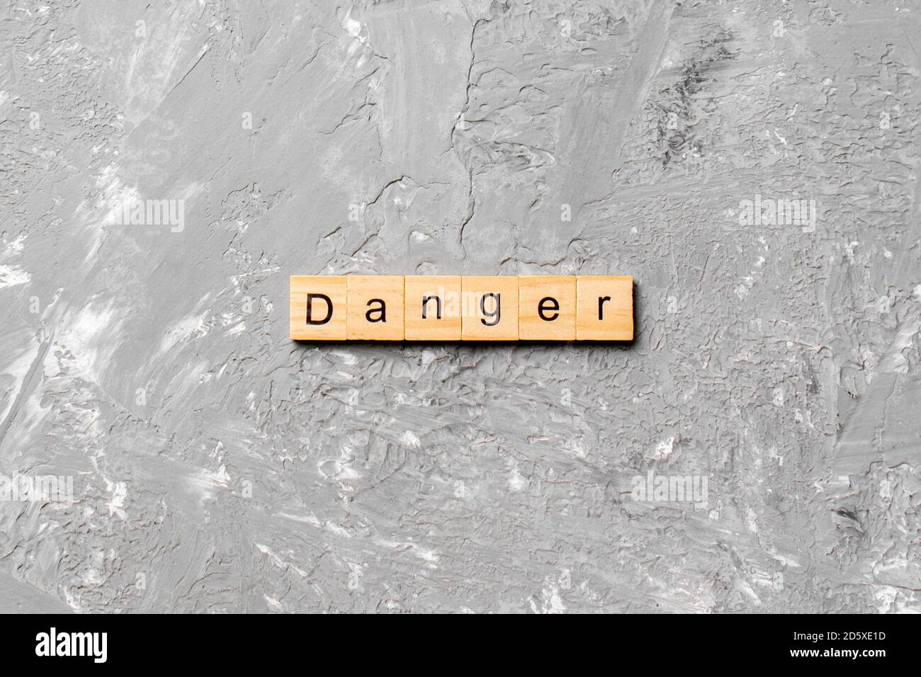 Danger word written on wood block. Danger text on cement table for your ...
