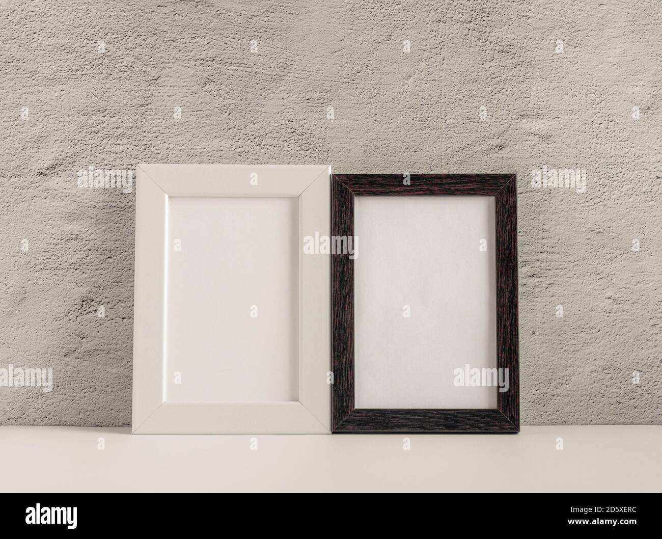 Two empty photo frames on a table or shelf with a copy of the space ...