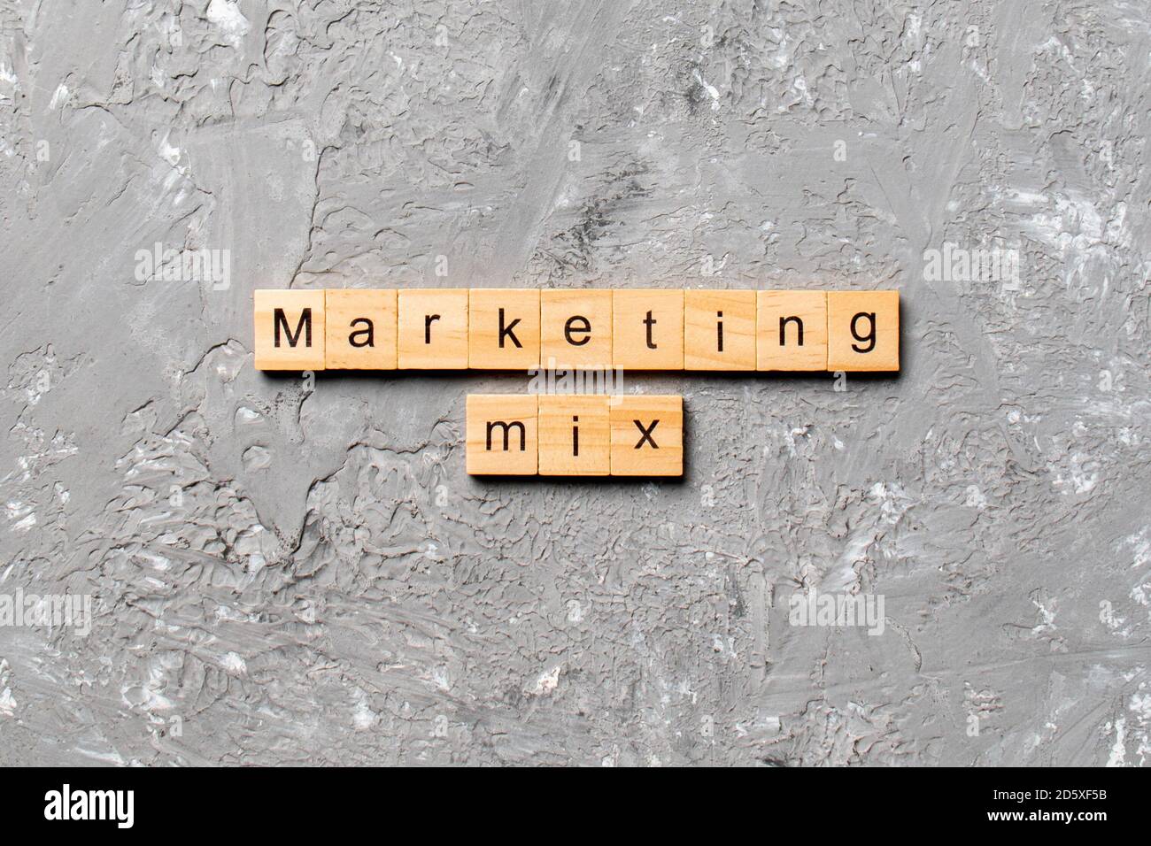 MARKETING MIX word written on wood block. MARKETING MIX text on cement ...