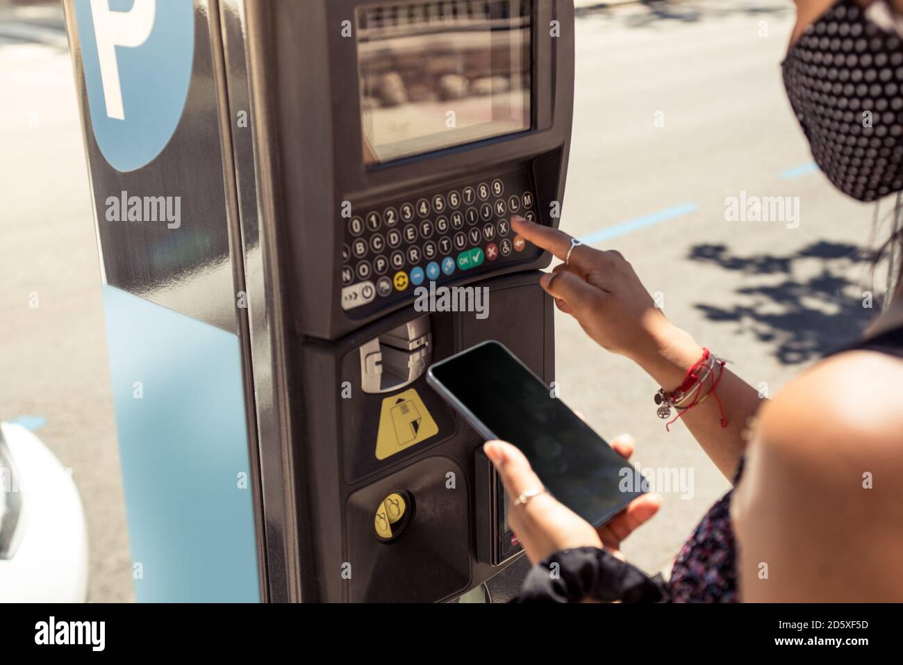Close up photography of woman using parking meter machine with the ...
