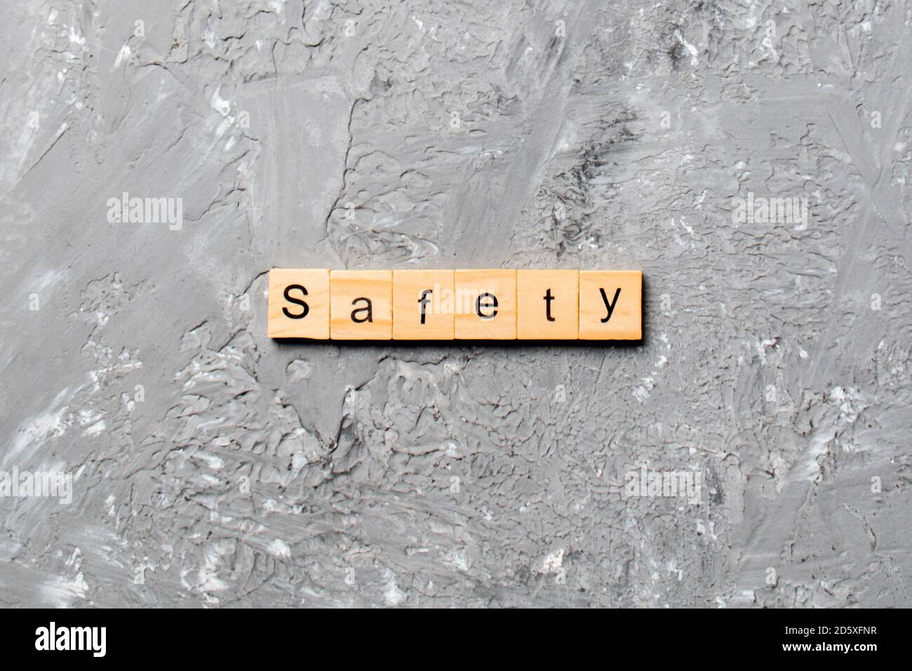 safety word written on wood block. safety text on cement table for your ...
