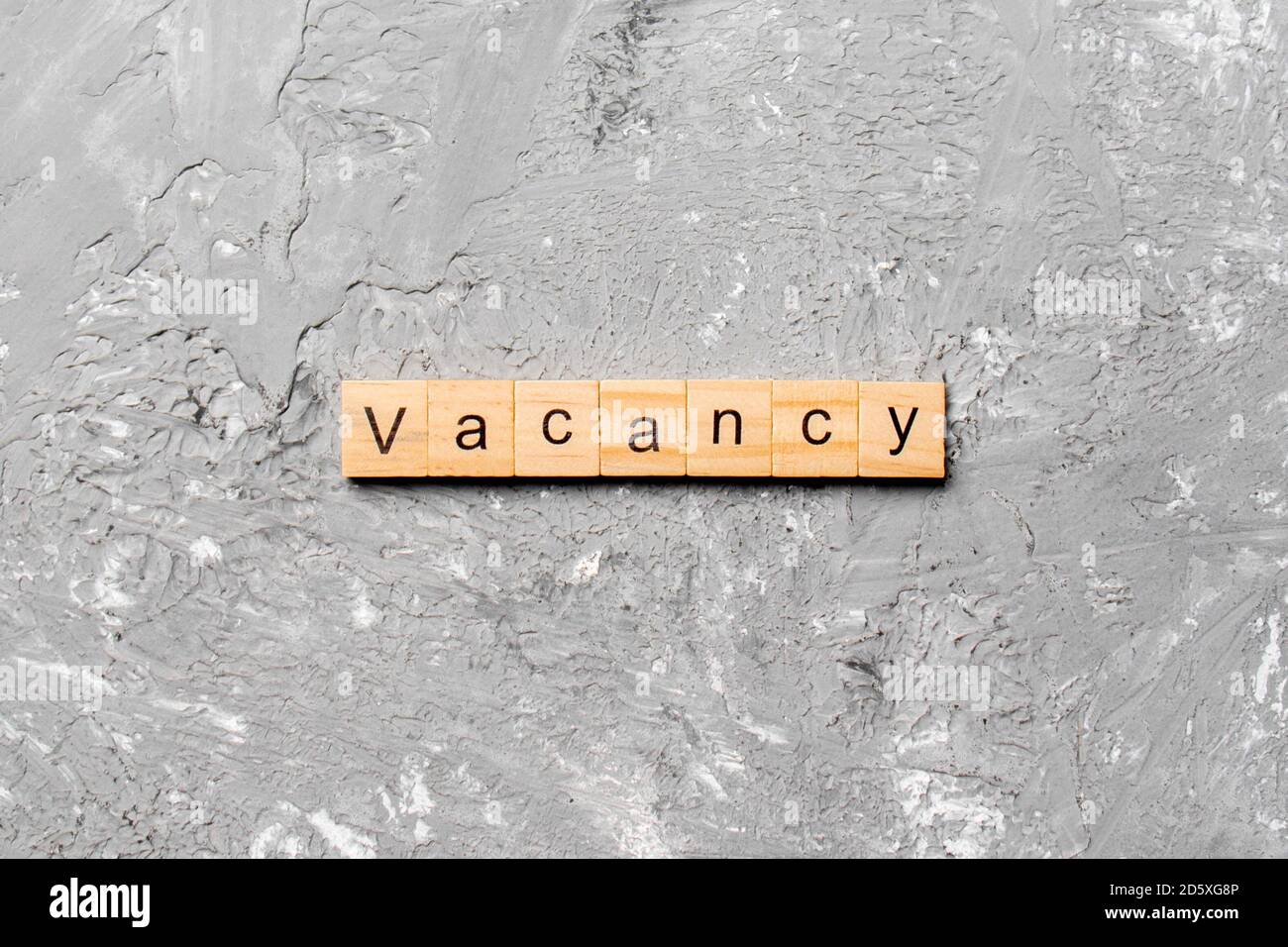 Vacancy word written on wood block. Vacancy text on cement table for ...