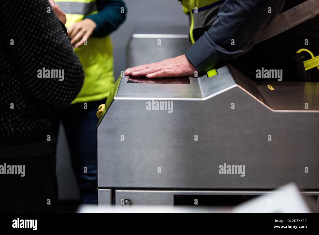 Security guard in subway station. Guard checking an automatic ticket ...