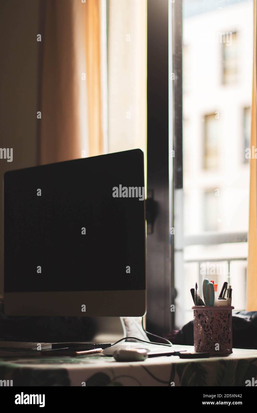 desk with computer and pens against window Stock Photo - Alamy
