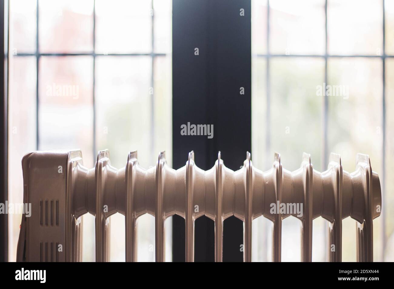 portable electric radiator against window in winter Stock Photo - Alamy