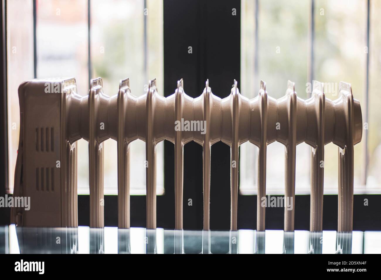 portable electric radiator against window in winter Stock Photo - Alamy