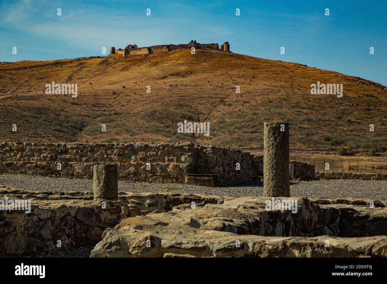 View of stone columns and hill with castle in the background Stock ...