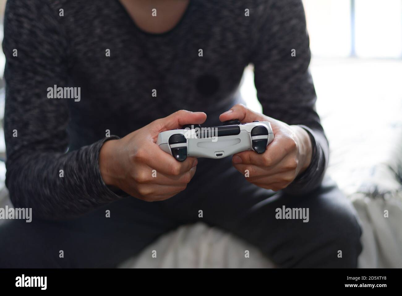A man holding a game controller. A young man playing video games Stock ...