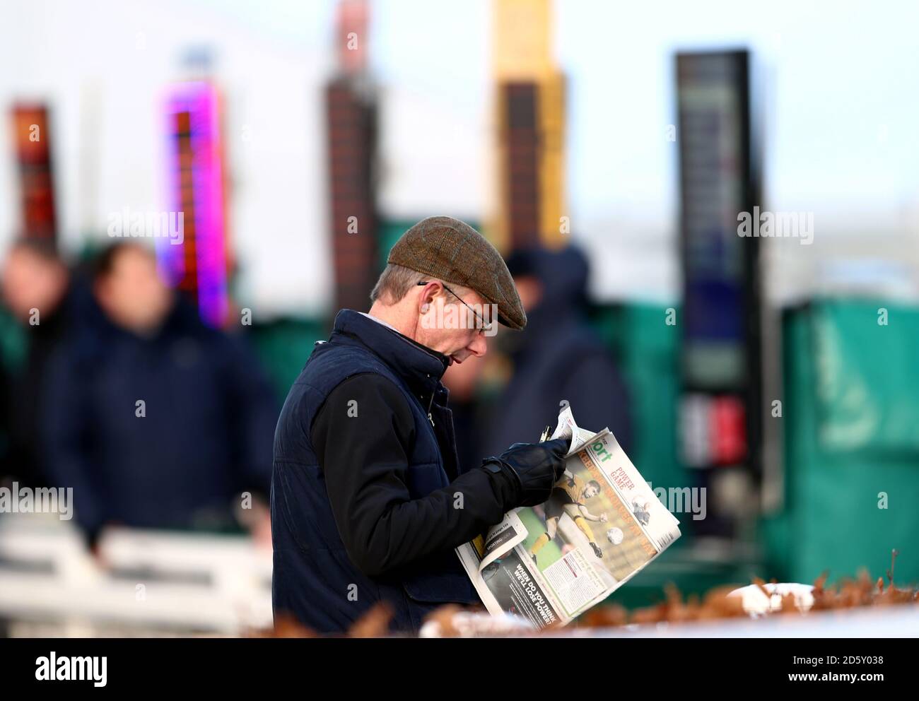 A racegoer checks the form in front of the bookies stands Stock Photo ...