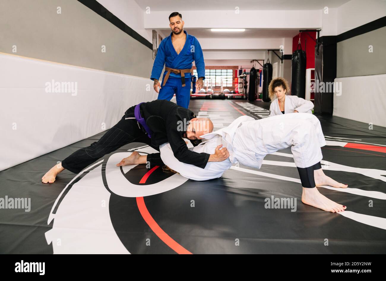 group of four judo martial arts partners and an instructor practicing ...