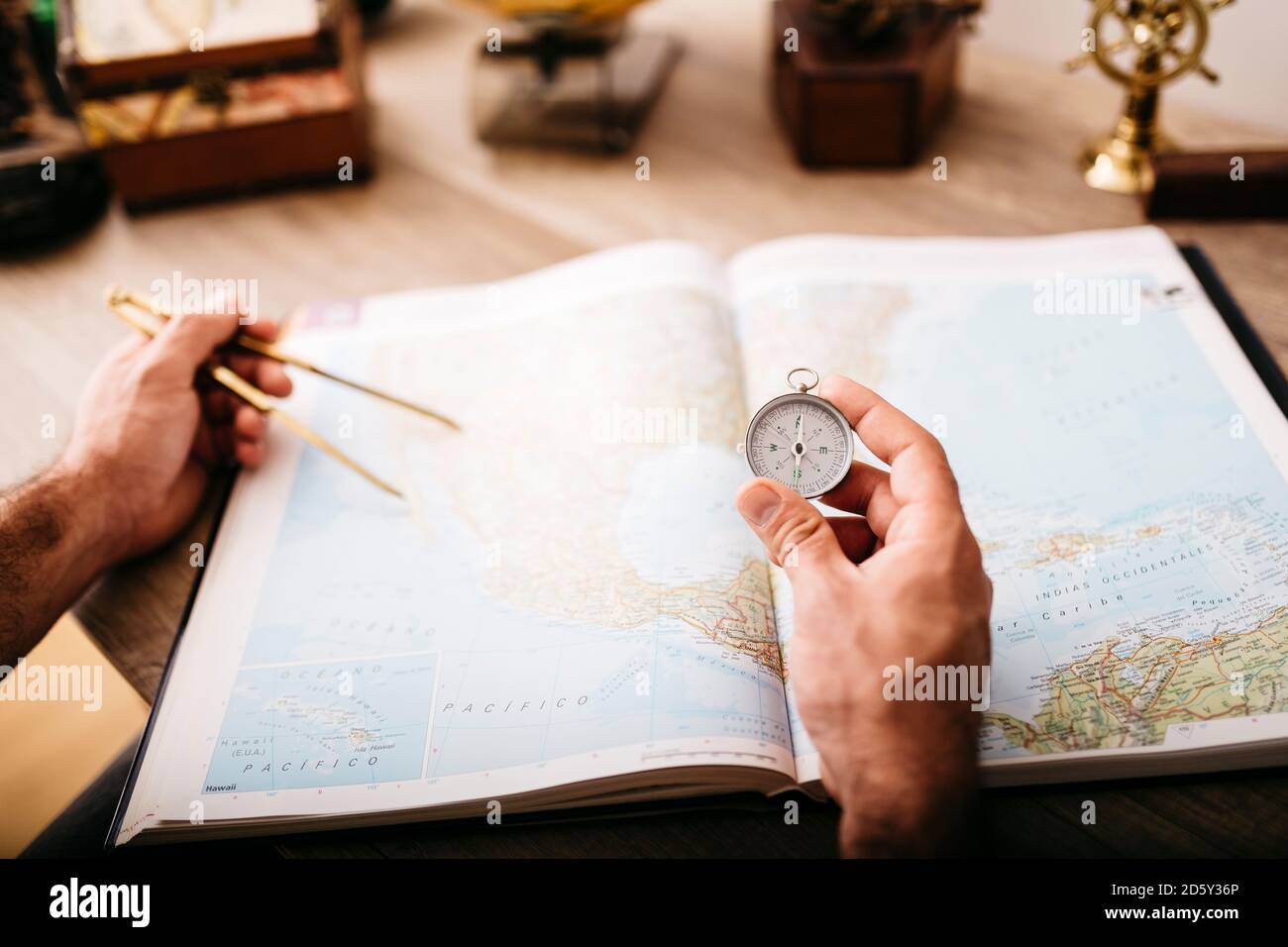 Young man planning journey using compasses Stock Photo - Alamy