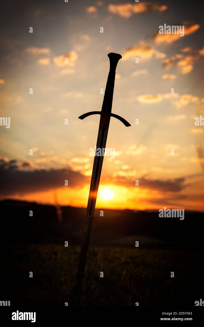 Sword in rural landscape at sunrise Stock Photo - Alamy
