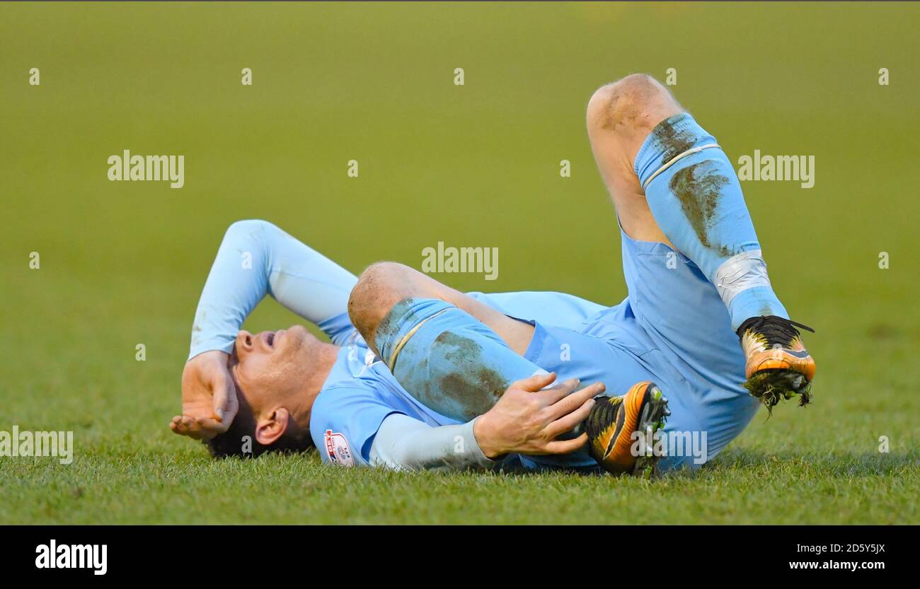Coventry City's Stuart Beavon holds his ankle as he lies injured on the ...