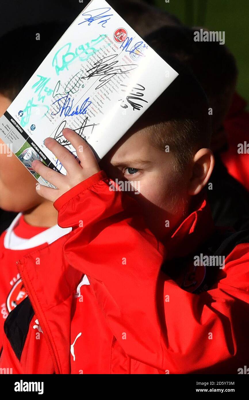 A young fan shields his face from the sun as he waits for autographs ...