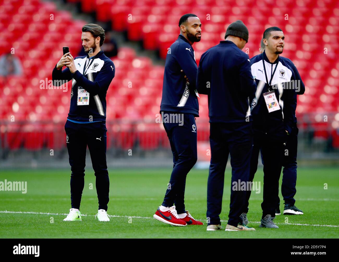 AFC Wimbledon's Callum Kennedy (left) takes a photo on the pitch Stock ...