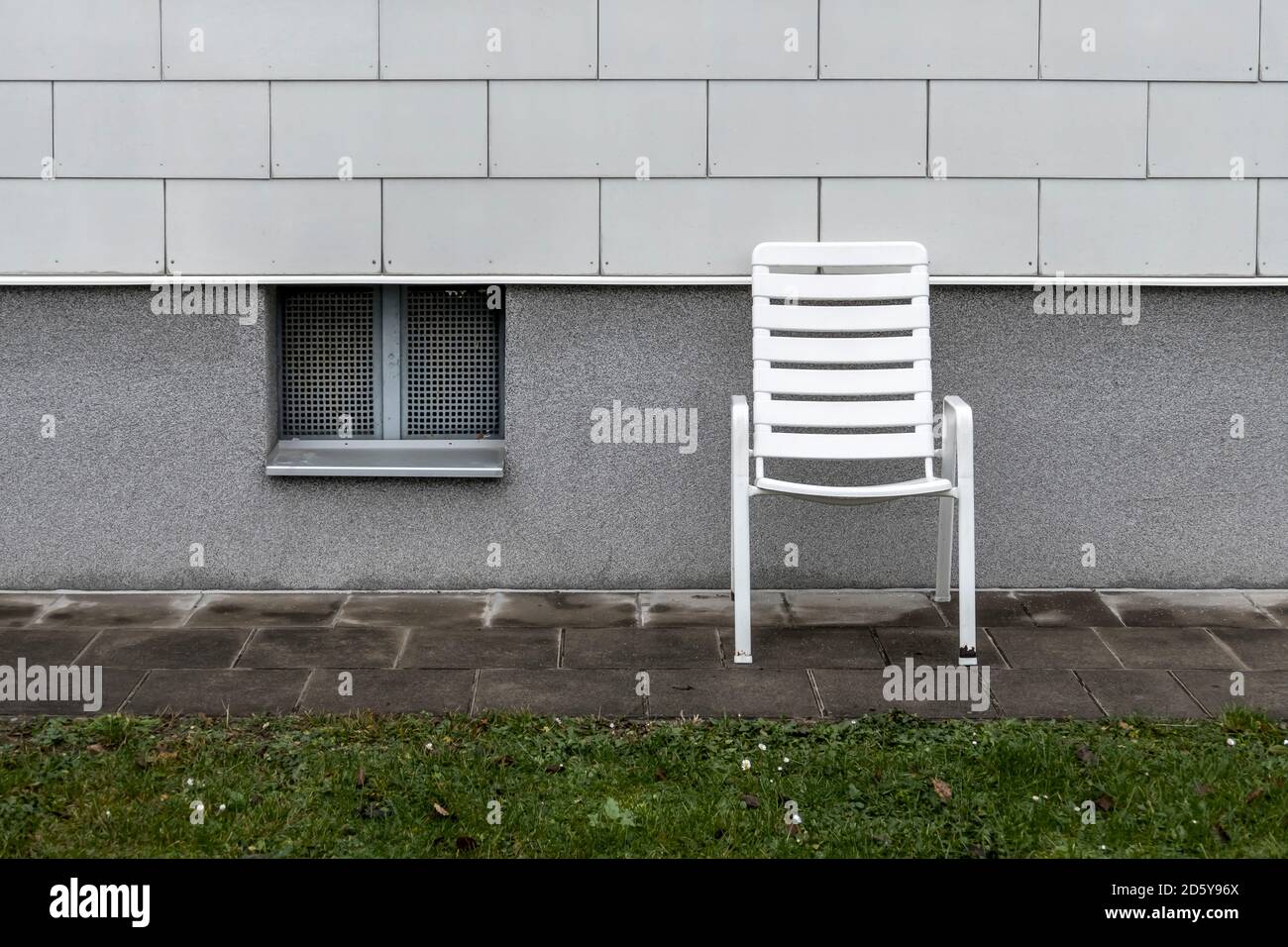 White plastic chair standing in front of a facade Stock Photo - Alamy