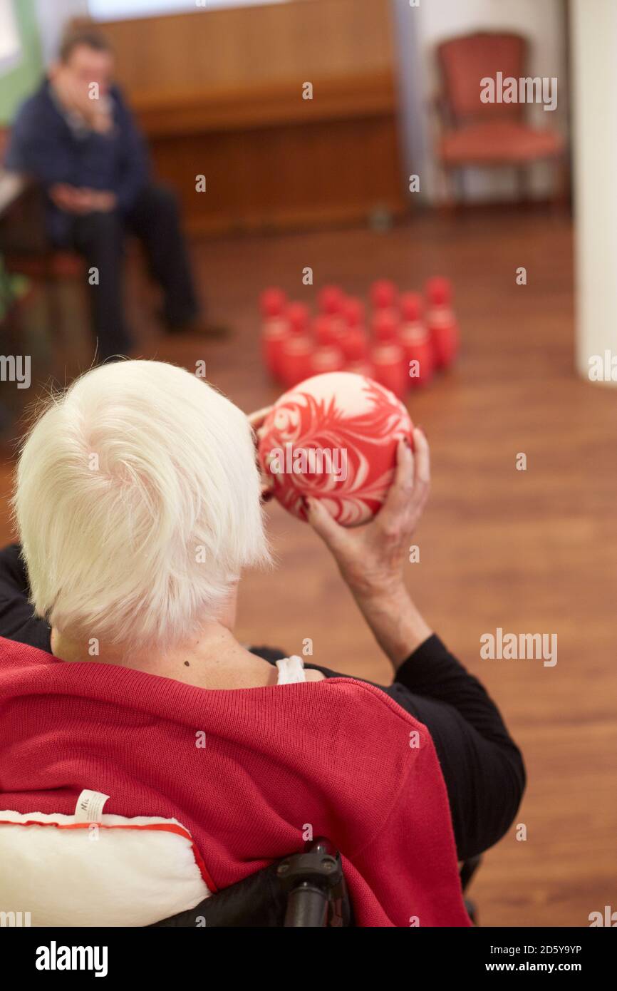 Age demented senior woman bowling with foam ball in a nursing home ...