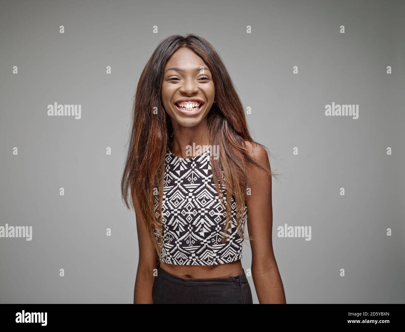 Portrait of laughing woman in front of grey background Stock Photo - Alamy