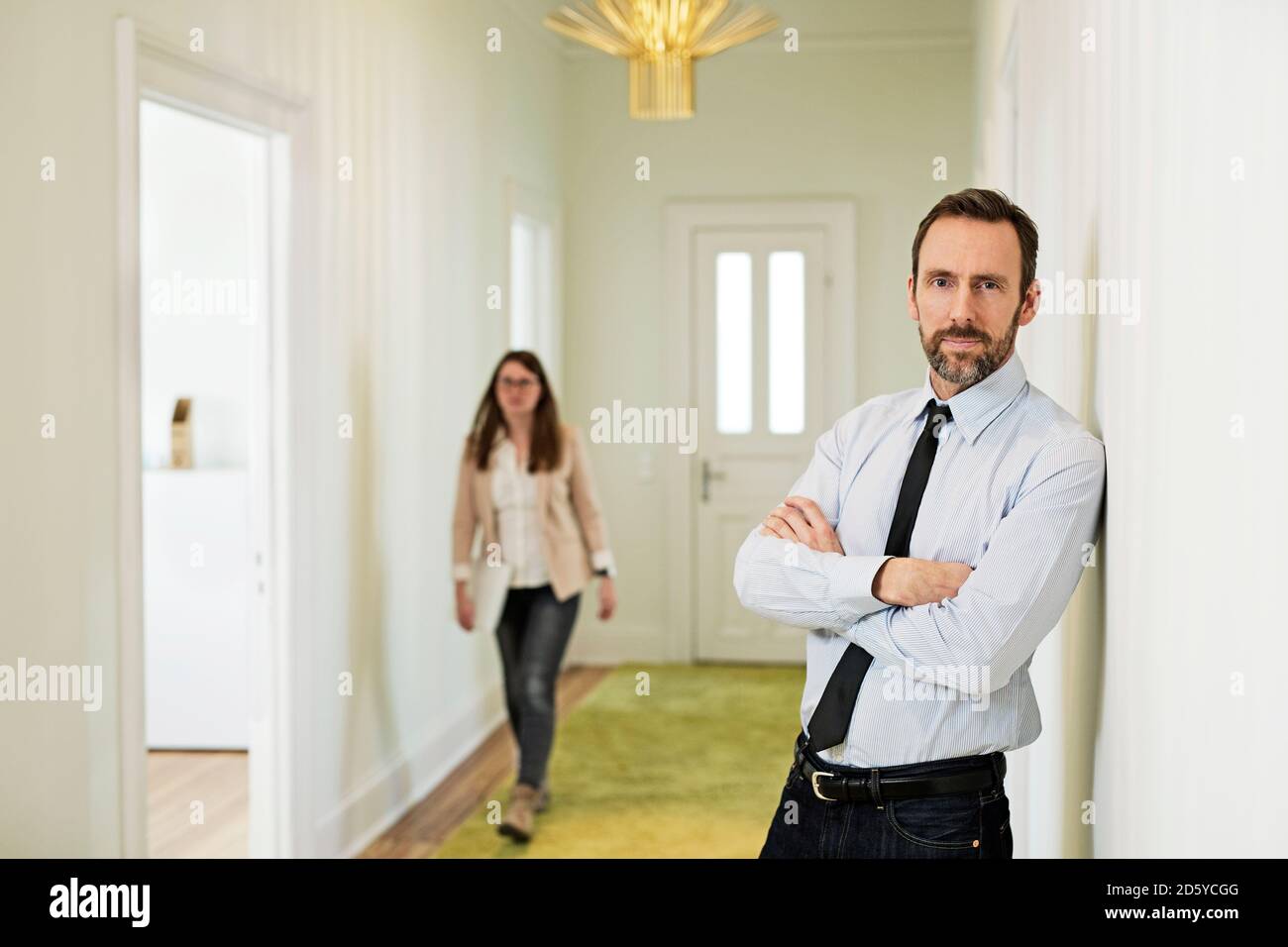 Portrait of businessman leaning against the wall on office floor Stock ...