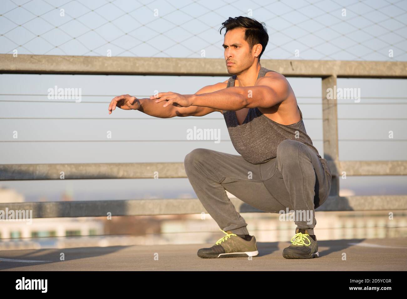 Muscular man doing squats Stock Photo - Alamy