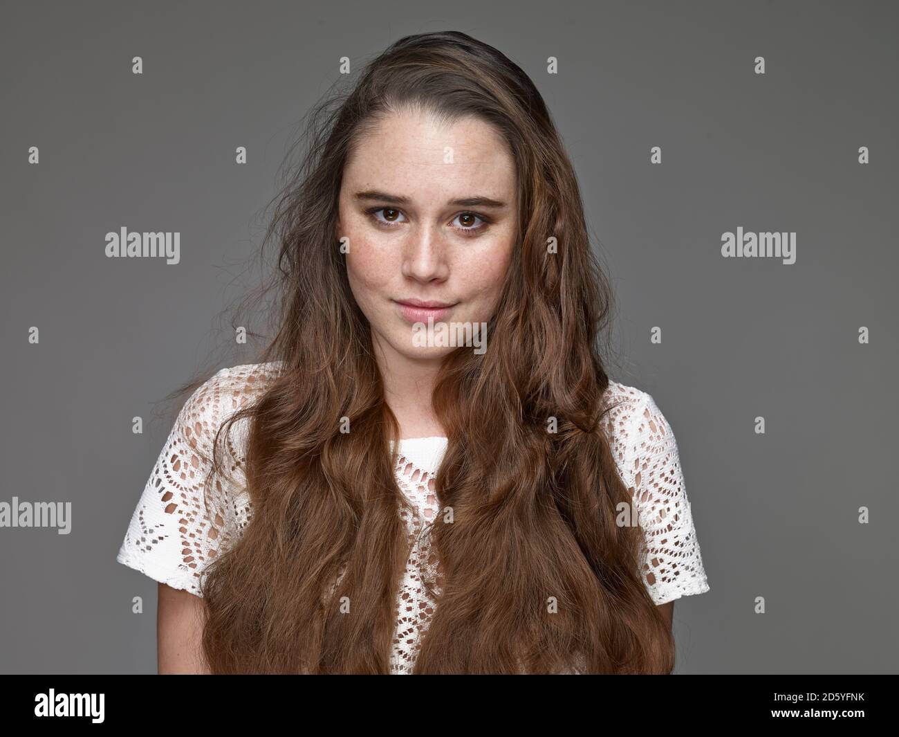 Portrait of smiling young woman with brown hair Stock Photo - Alamy