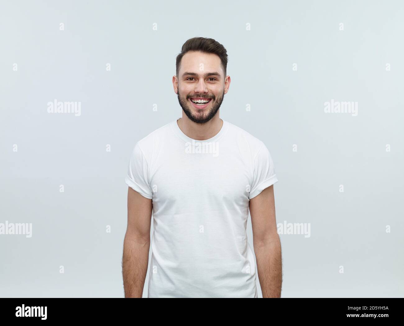 Portrait of laughing young man in front of light background Stock Photo ...