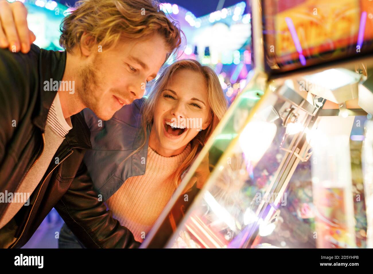 Young couple at fun fair looking at prizes in window Stock Photo - Alamy