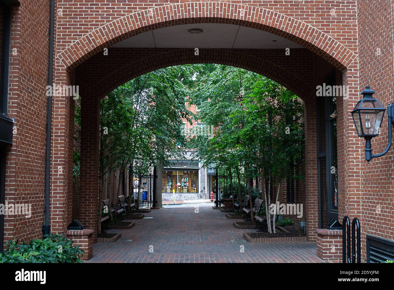 brick building with arched entrance. Trees and benches to sit and rest ...