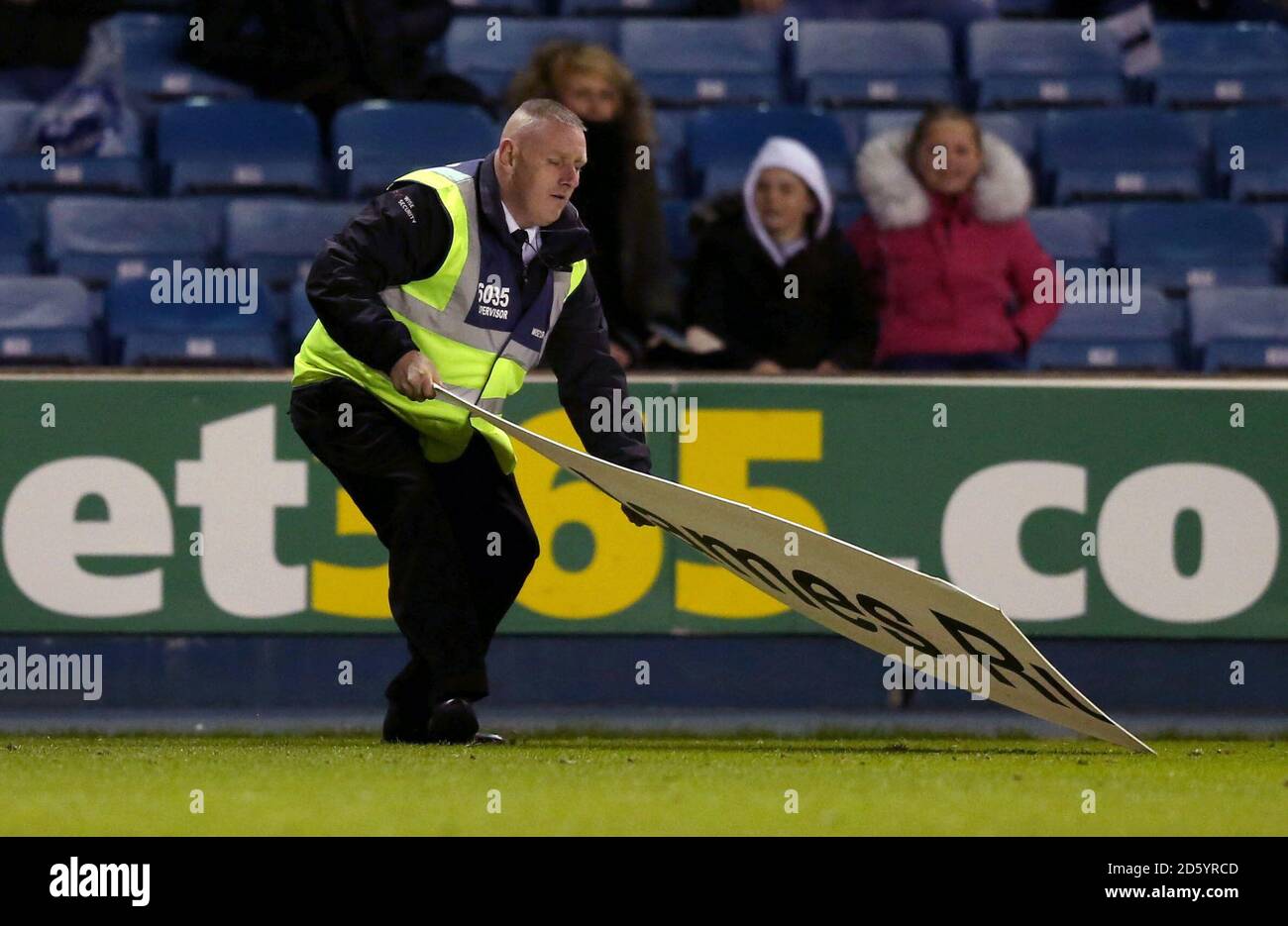 A steward removes a piece of advertising hoarding that blew onto the ...