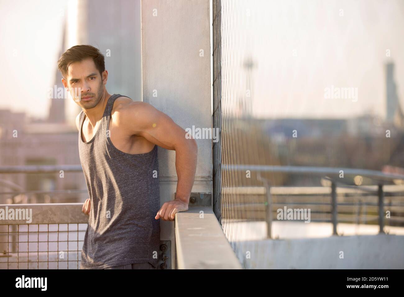 Portrait of muscular sportsman leaning on railing Stock Photo - Alamy