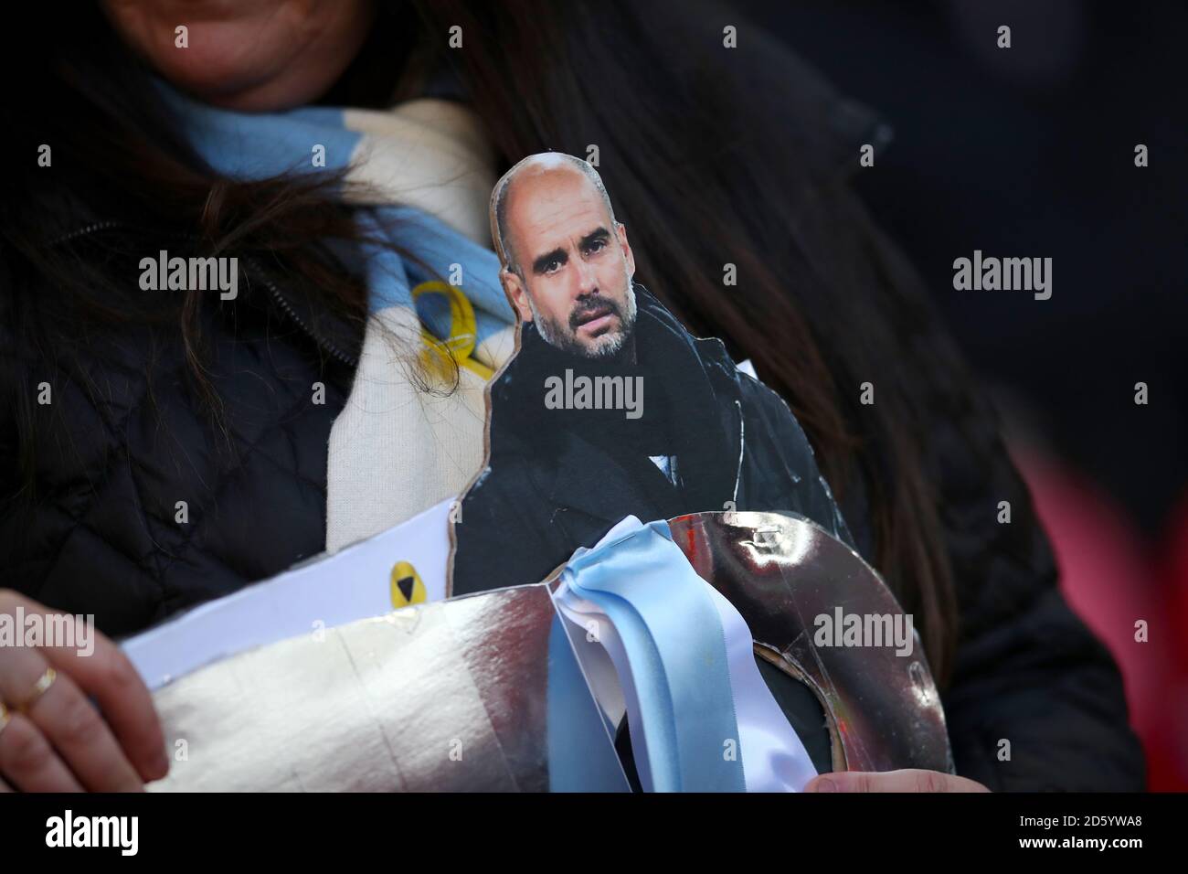 A Manchester City fan carries a cardboard cutout of Manchester City ...