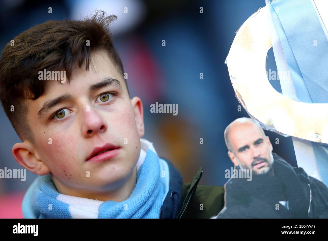 A Manchester City fan carries a cardboard cutout of Manchester City ...