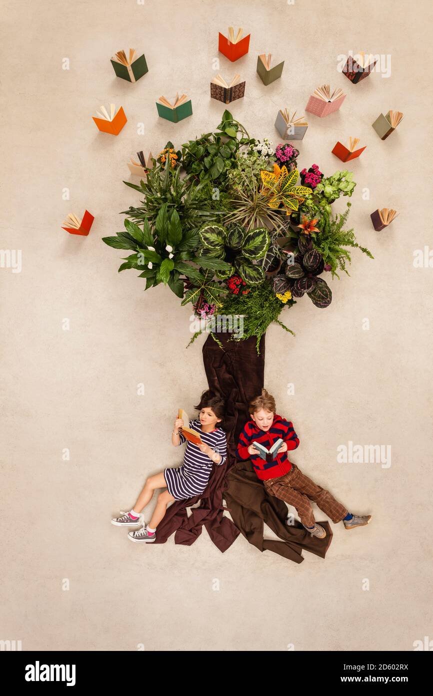 Girl reading under tree hi-res stock photography and images - Alamy