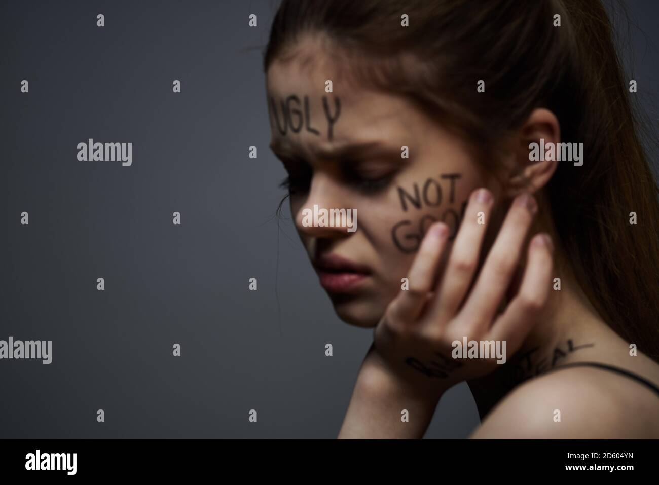 Emotional woman with inscriptions on body upset with frustration gray ...
