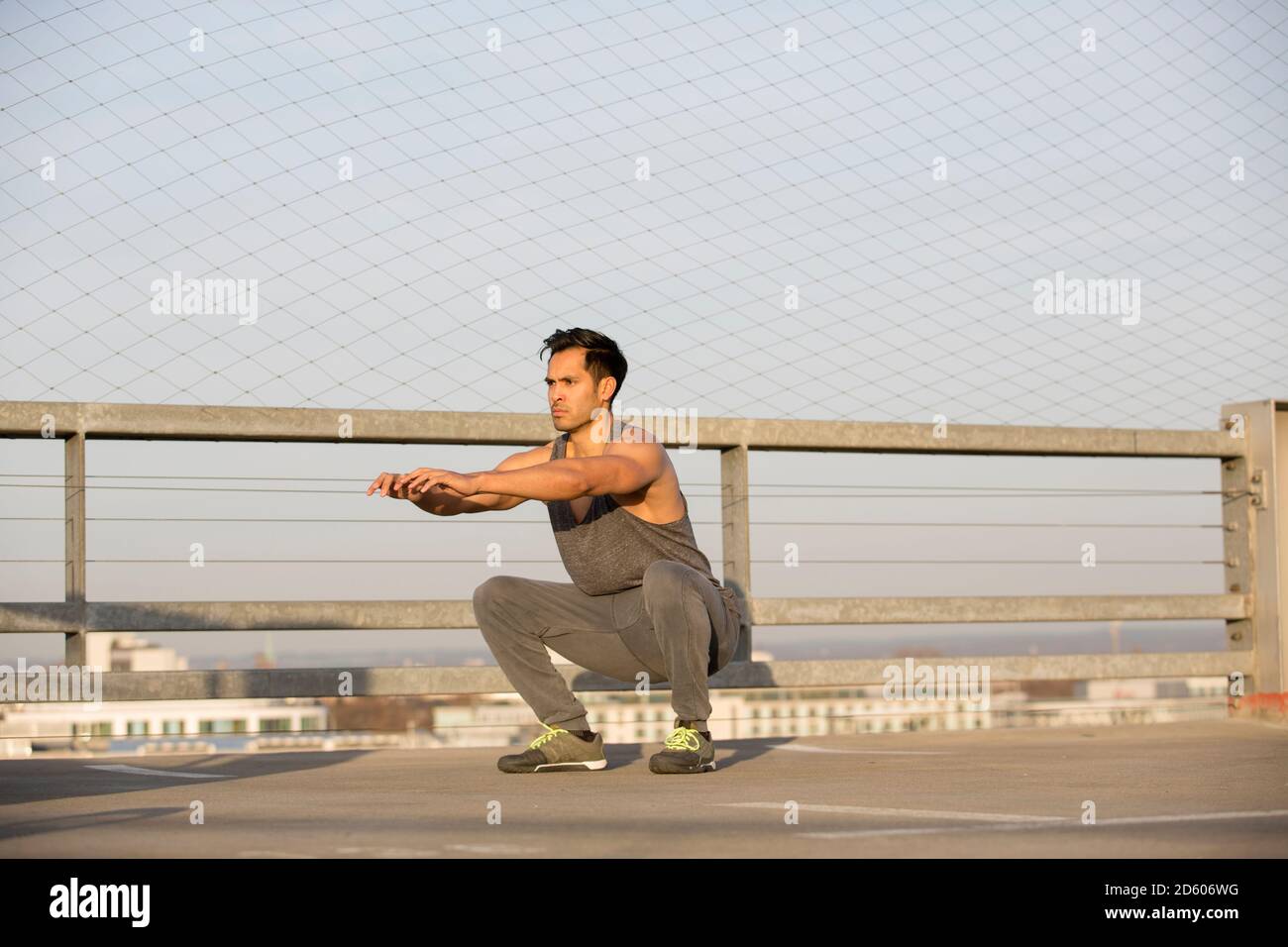 Muscular man doing squats Stock Photo - Alamy