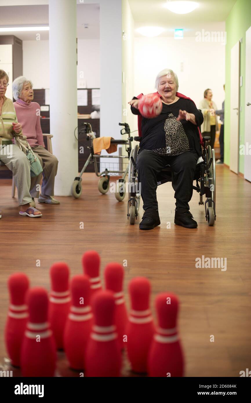 Age demented senior woman bowling with foam ball in a nursing home ...