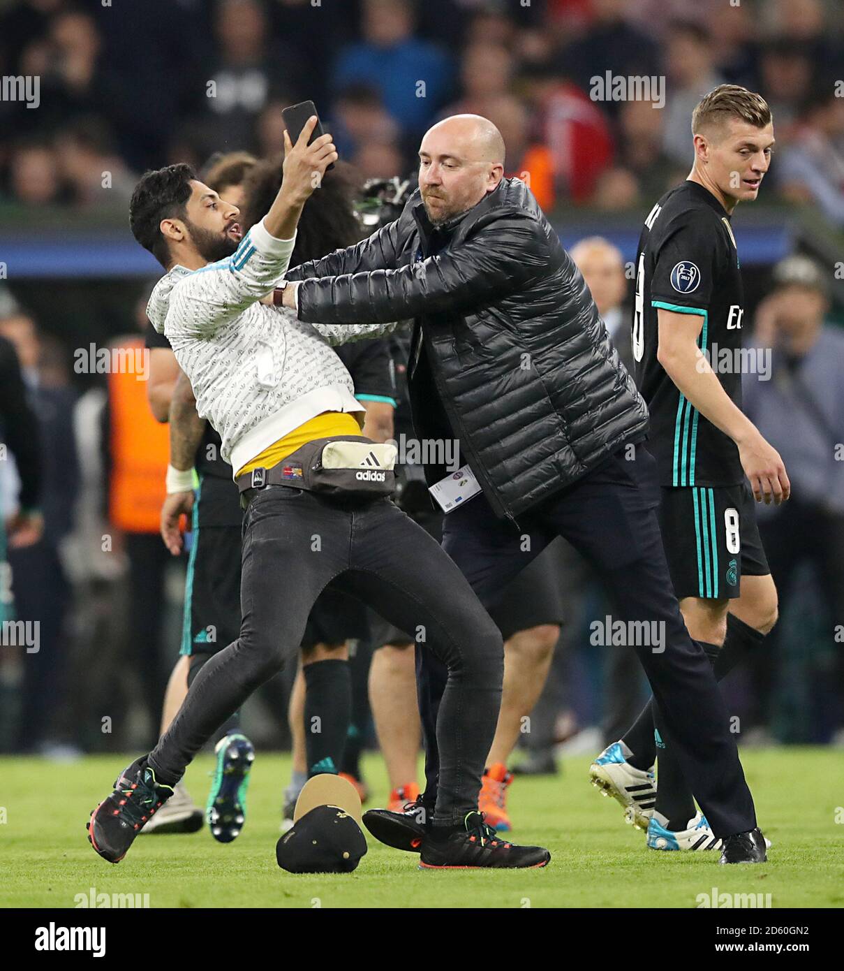 A pitch invader is challenged by security after the final whistle Stock ...