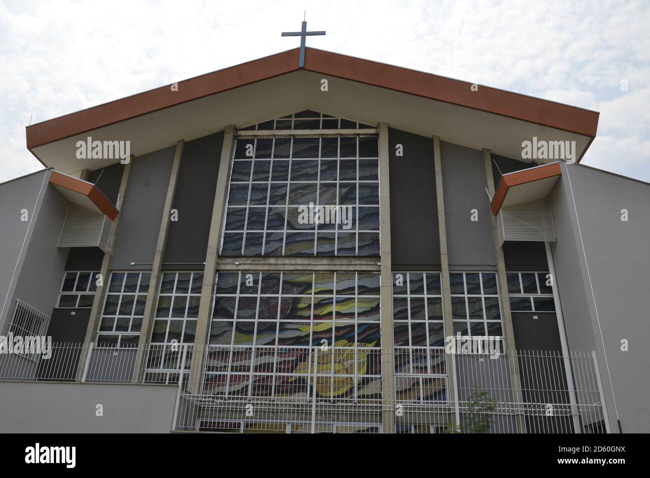 Catholic church facade, bottom-up view, with bars and a cross on top ...