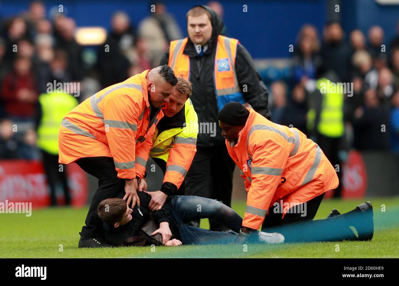 A pitch invader is restrained by security staff Stock Photo - Alamy