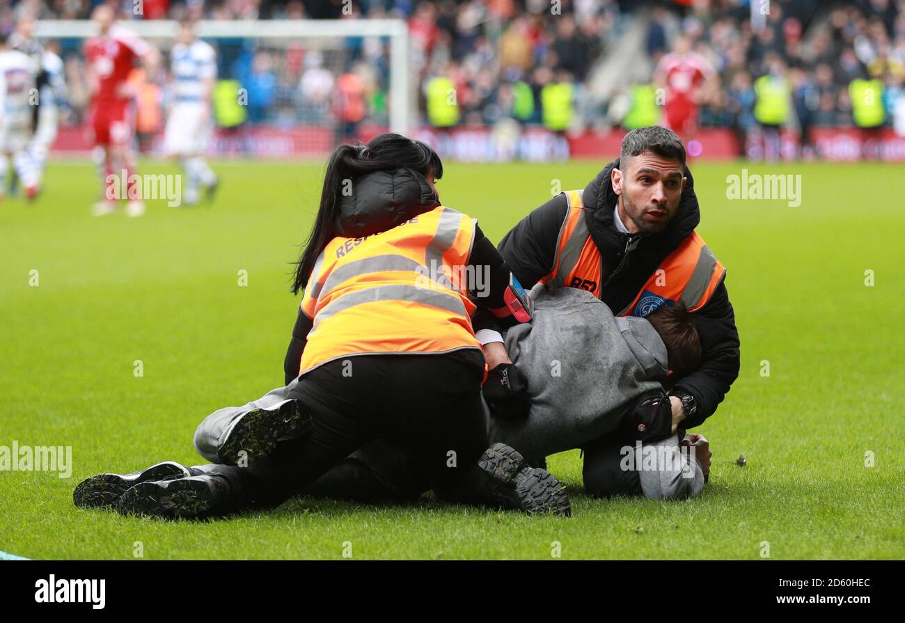 A pitch invader is restrained by security staff Stock Photo - Alamy