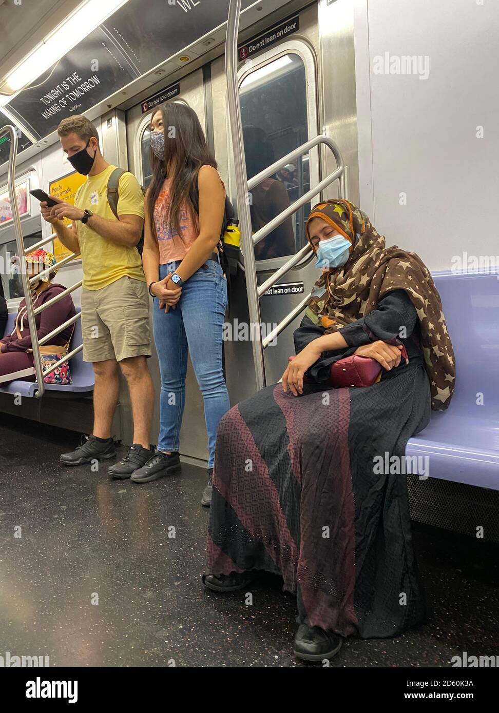 Riders social distance as best they can riding a subway train in New ...