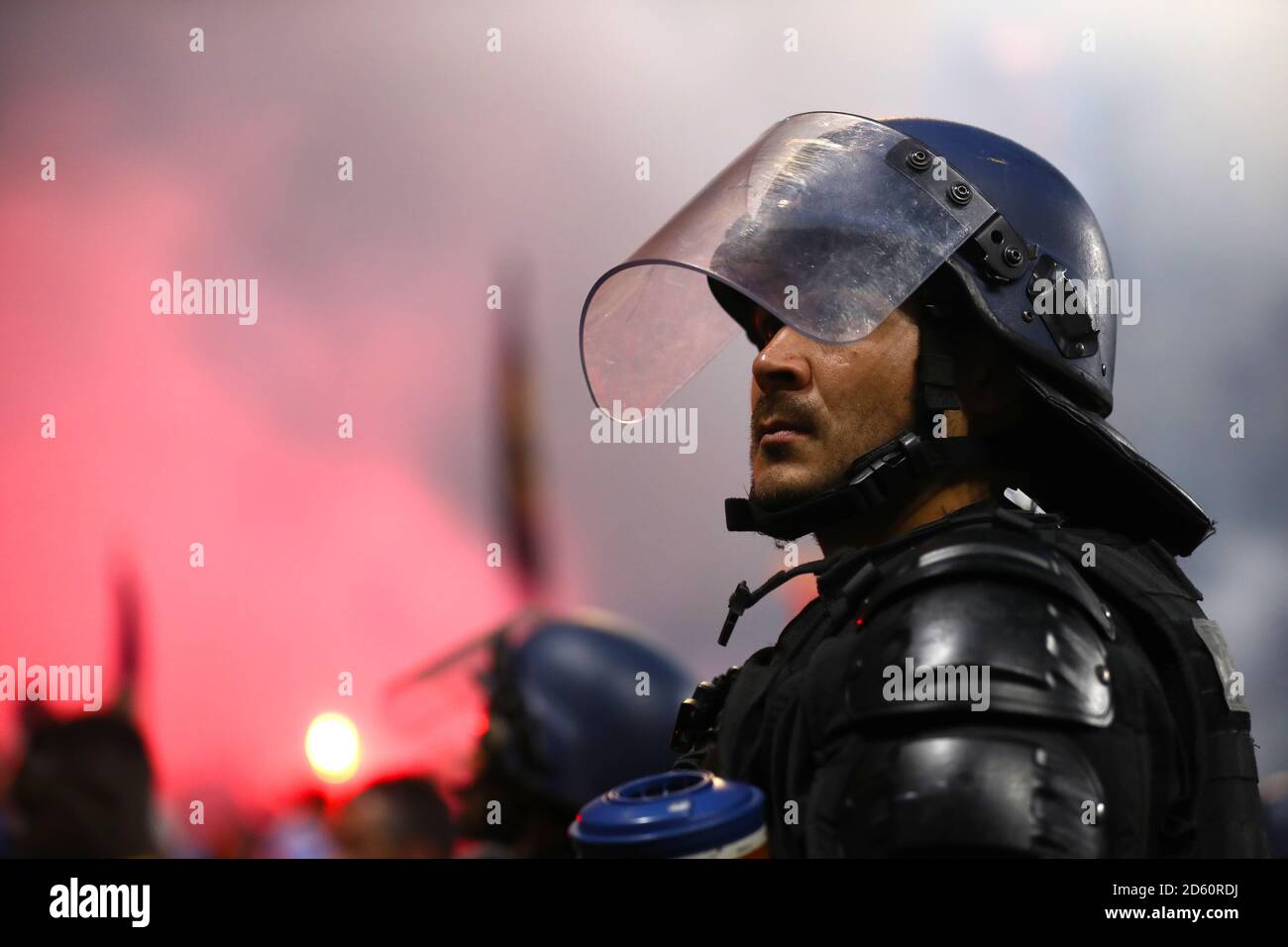 A Police officer wearing a riot mask looks on during the match Stock ...