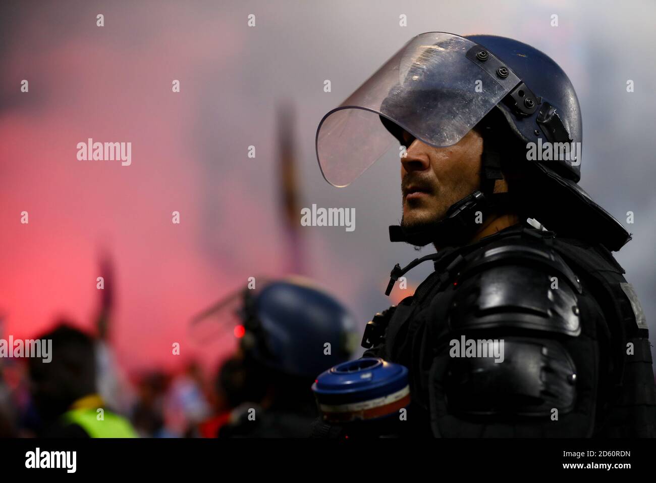 A Police officer wearing a riot mask looks on during the match Stock ...