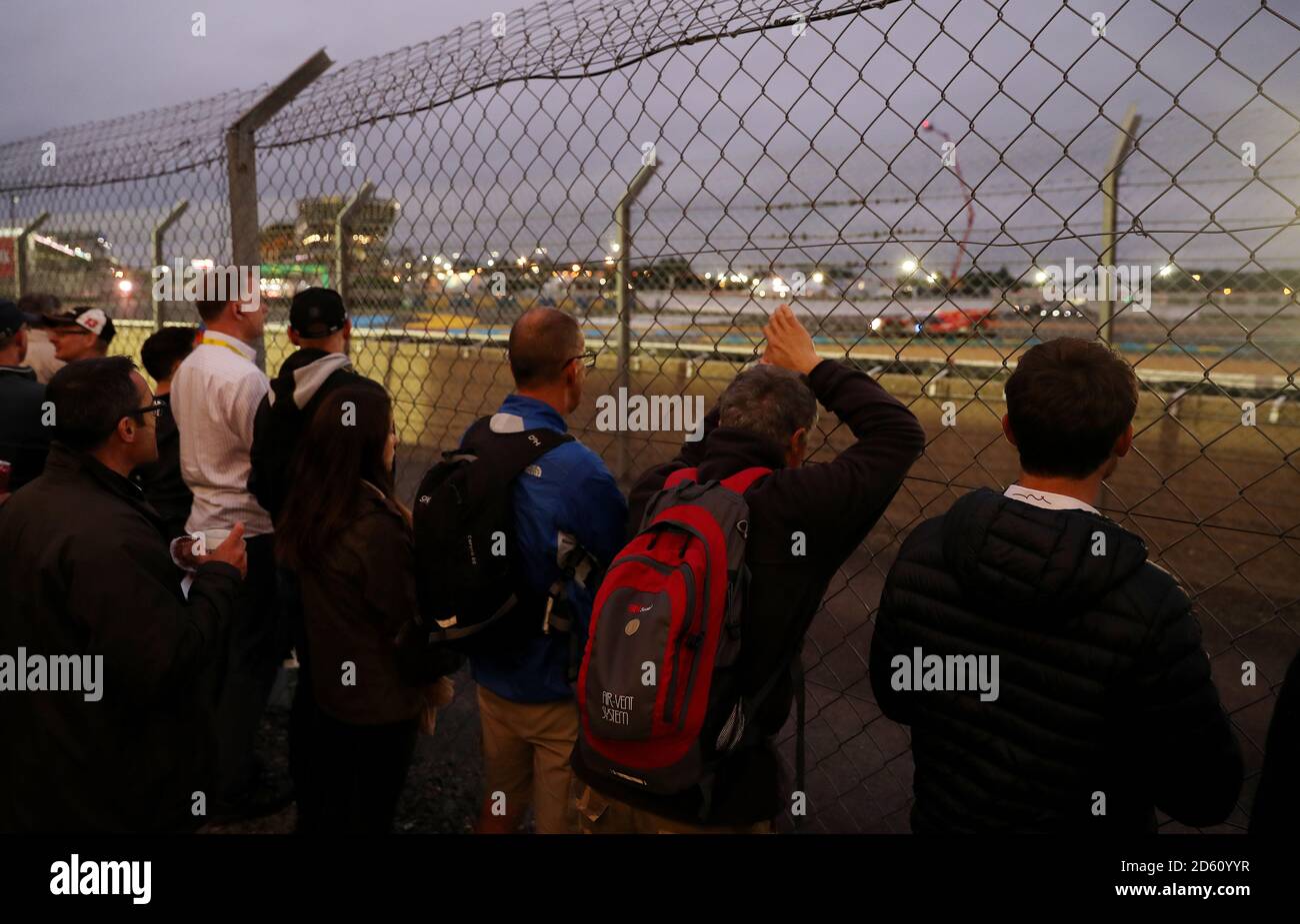 Fans watch through the fence Stock Photo - Alamy
