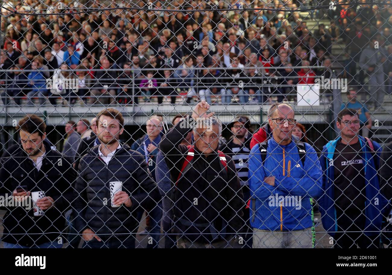 Fans watch through the fence Stock Photo - Alamy