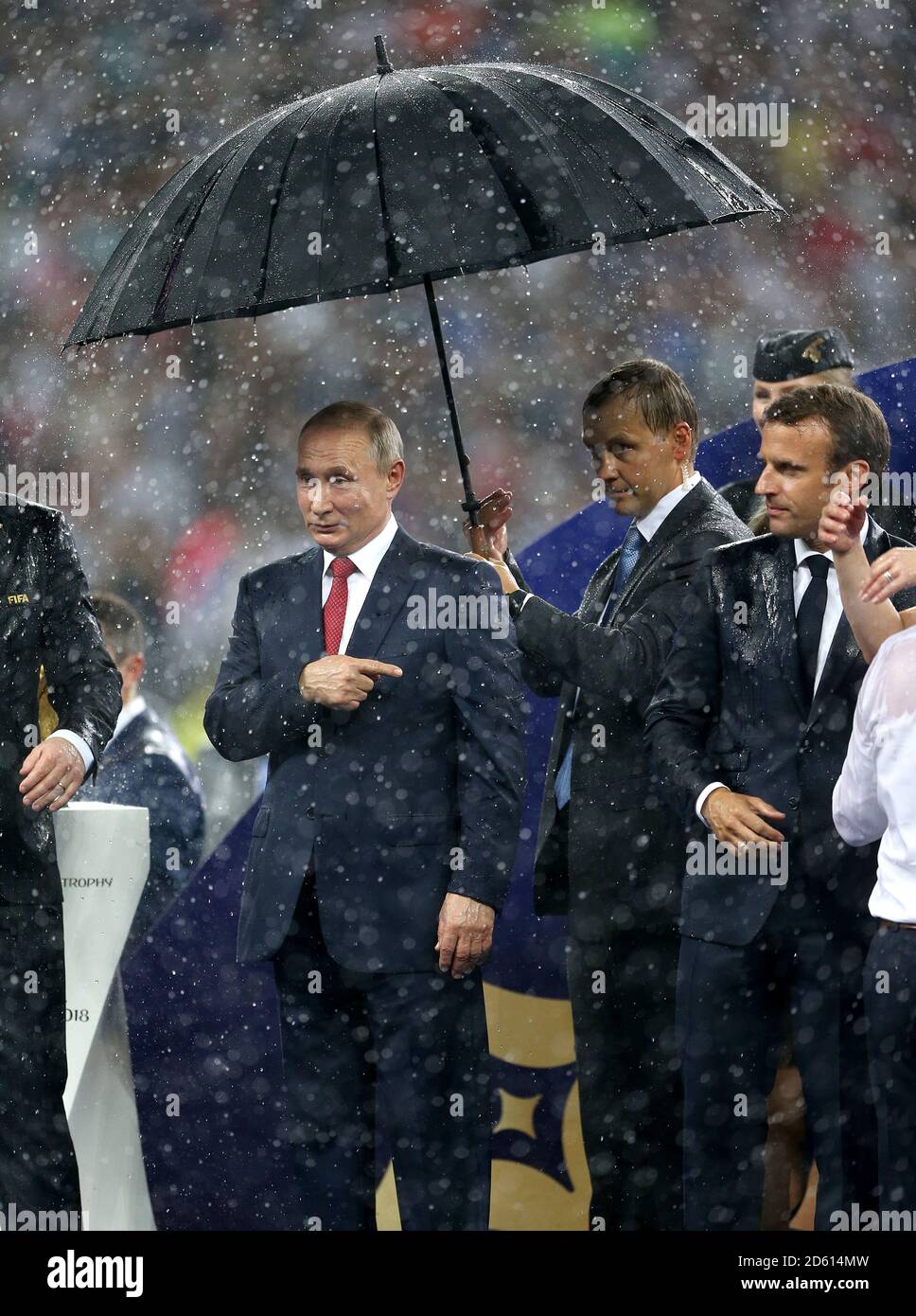 Russian President Vladimir Putin is shielded from the rain after the ...