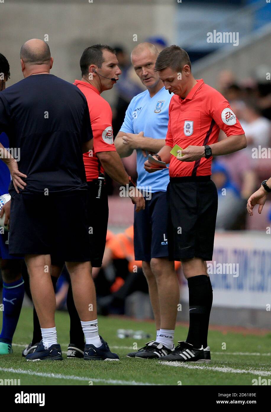 Referee Tim Robinson (left) leaves the field unable to continue the ...