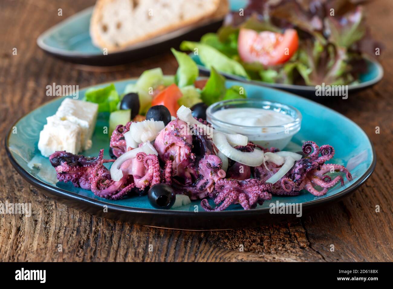 octopus and tsatsiki on a blue plate Stock Photo - Alamy