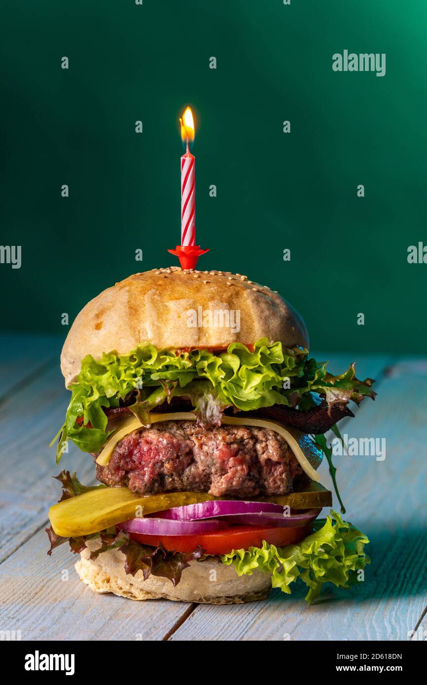single cheeseburger with a burning candle Stock Photo - Alamy