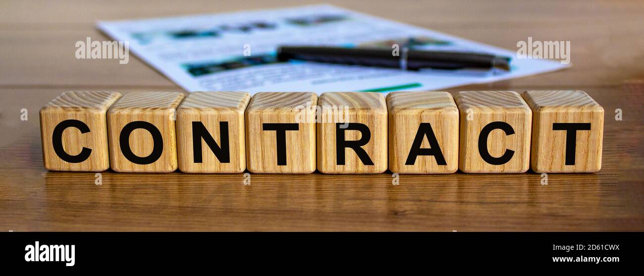 Concept word 'contract' on cubes on a beautiful wooden table, pen and ...